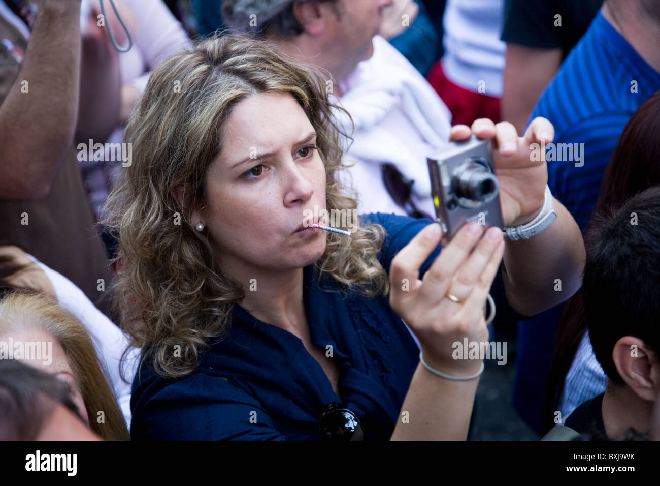 Woman spectator / photographer prepares to take a picture / photograph ...