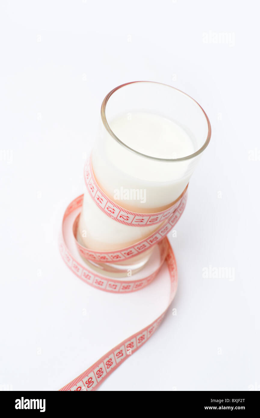 glass of kefir wound with a measuring tape as concept of cultured milk ...