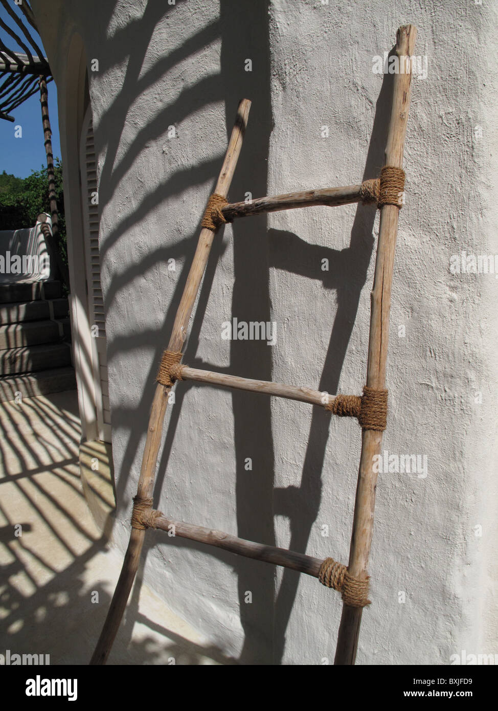 Stick ladder leaning against a wall with shadows Stock Photo - Alamy