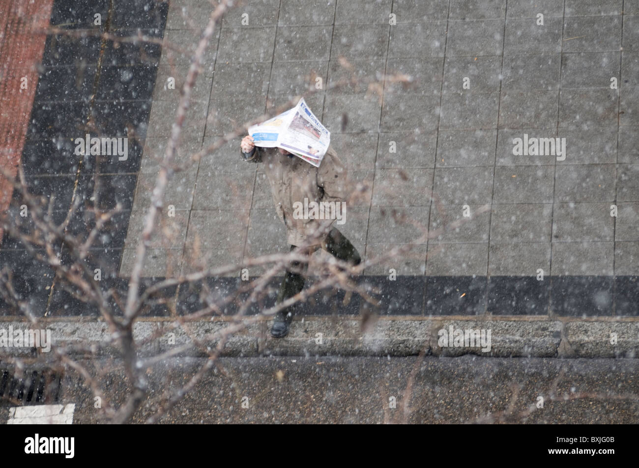 snow scene in the city.man with newspaper over the head Stock Photo - Alamy