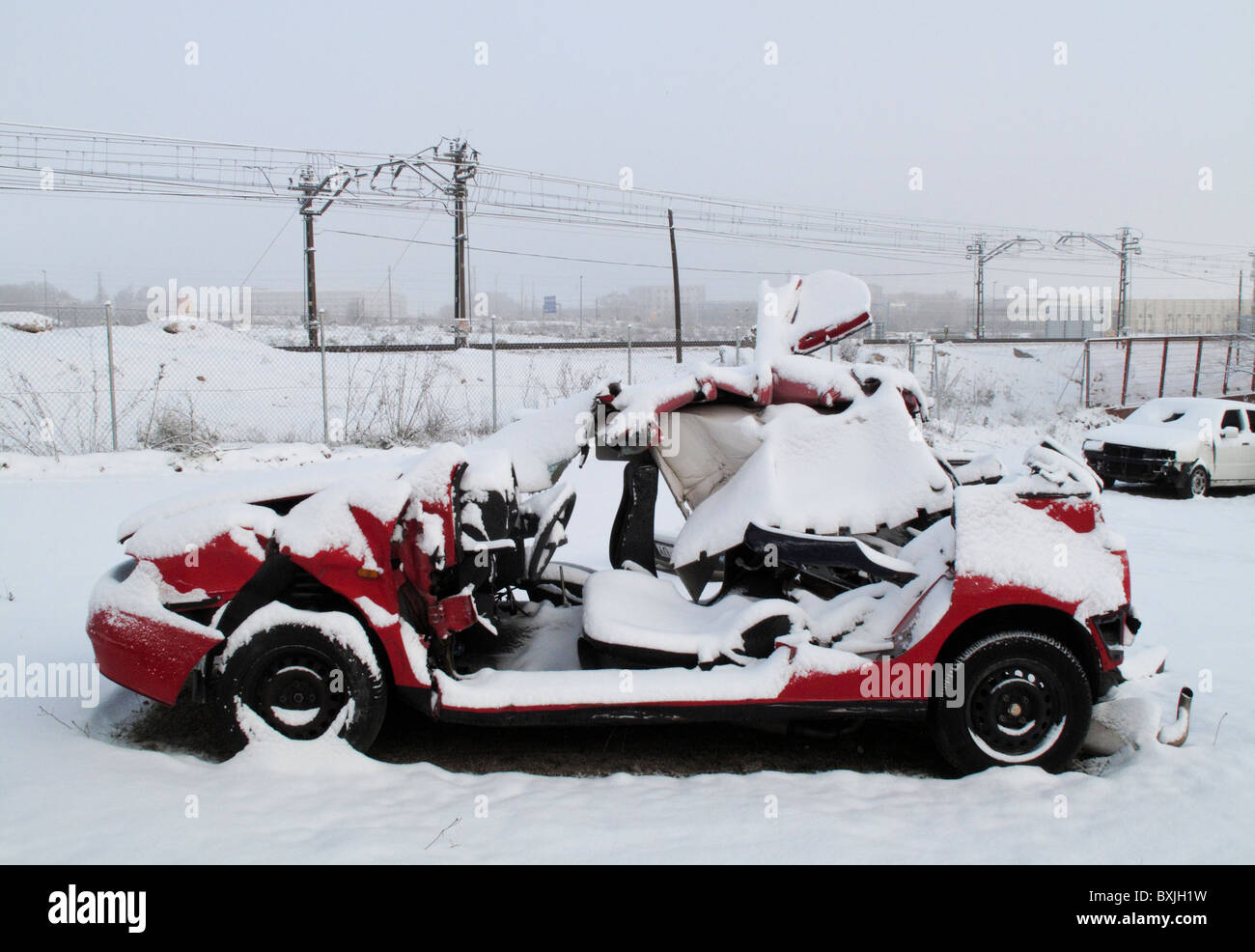 crashed red car under snow,broken up car under snow near railways Stock ...