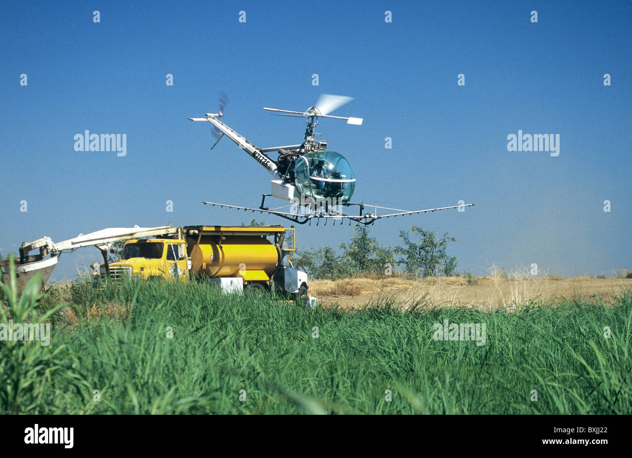 Rice field, helicopter departing from truck mounted service platform ...