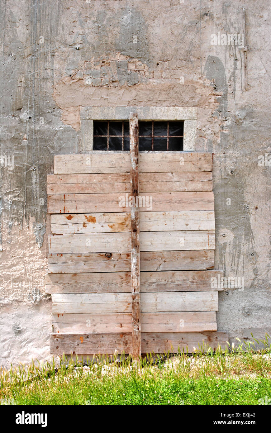 old wooden door below street level with a small window Stock Photo - Alamy