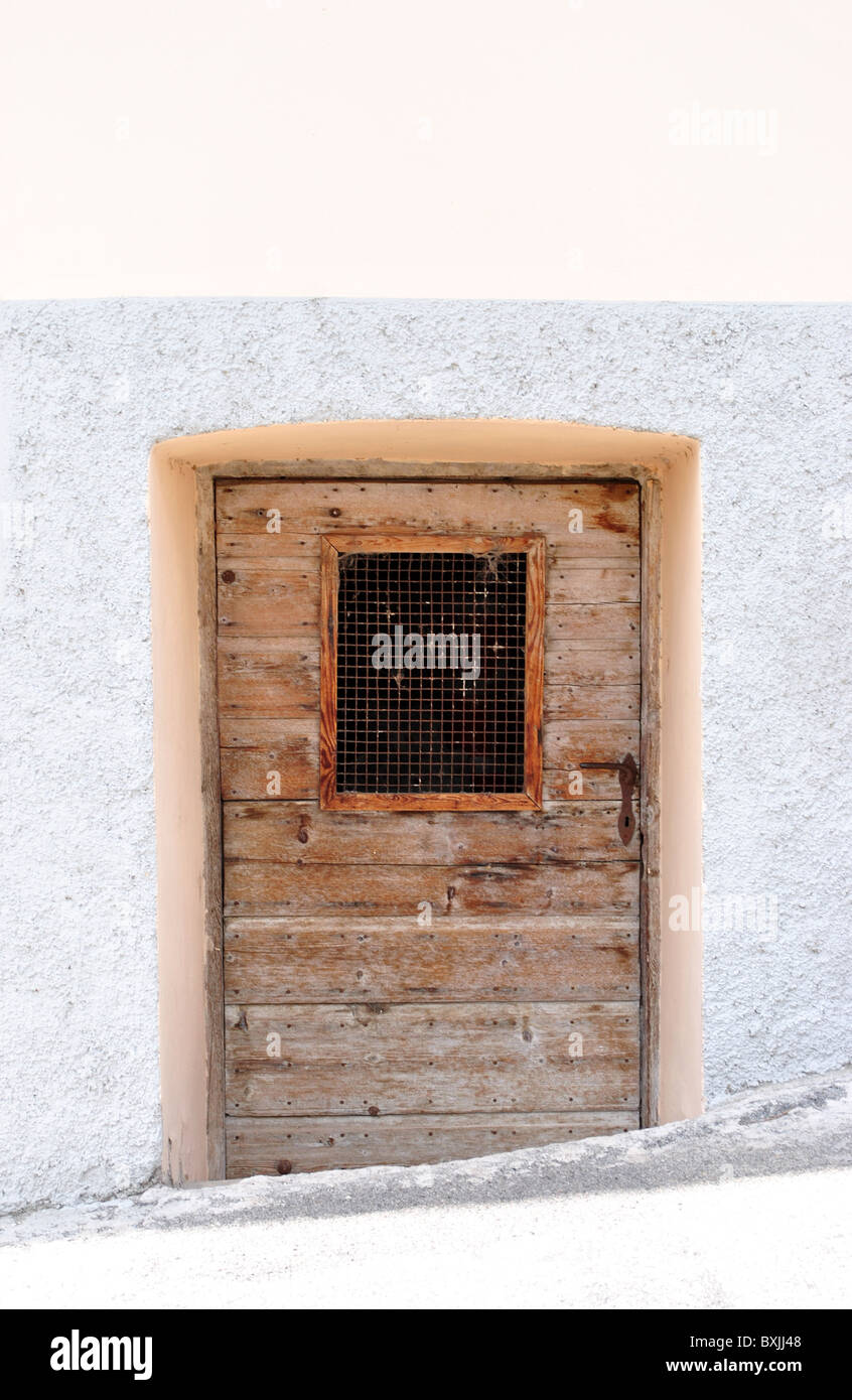 old wooden door below street level with a small window Stock Photo - Alamy