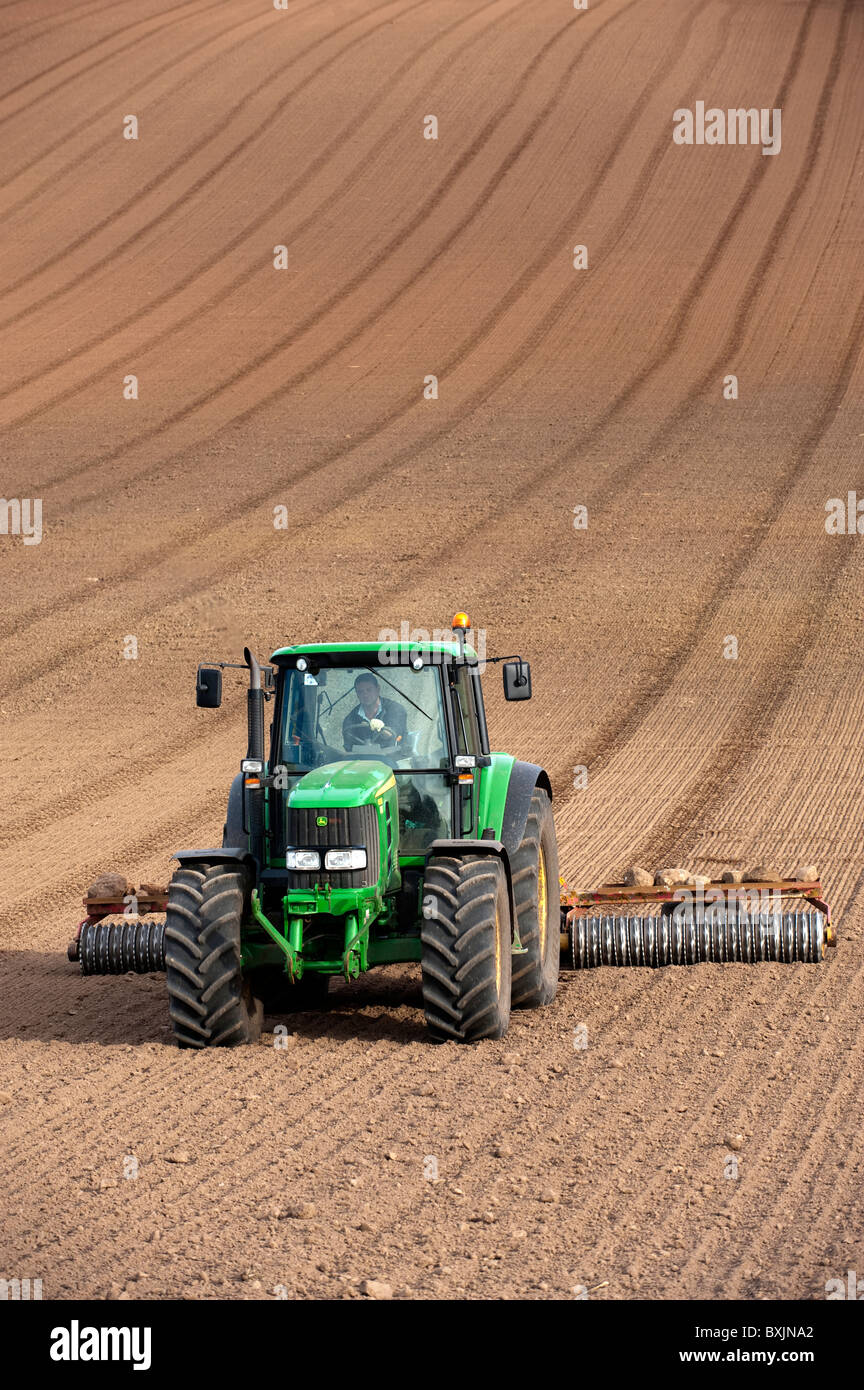 Farmer with soil press rolling seedbed, using John Deere tractor. Kelso ...