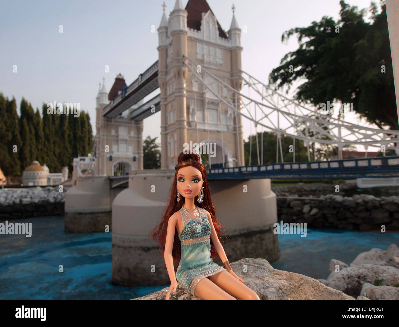 Barbie doll sitting next to the model of the mini London bridge at the ...