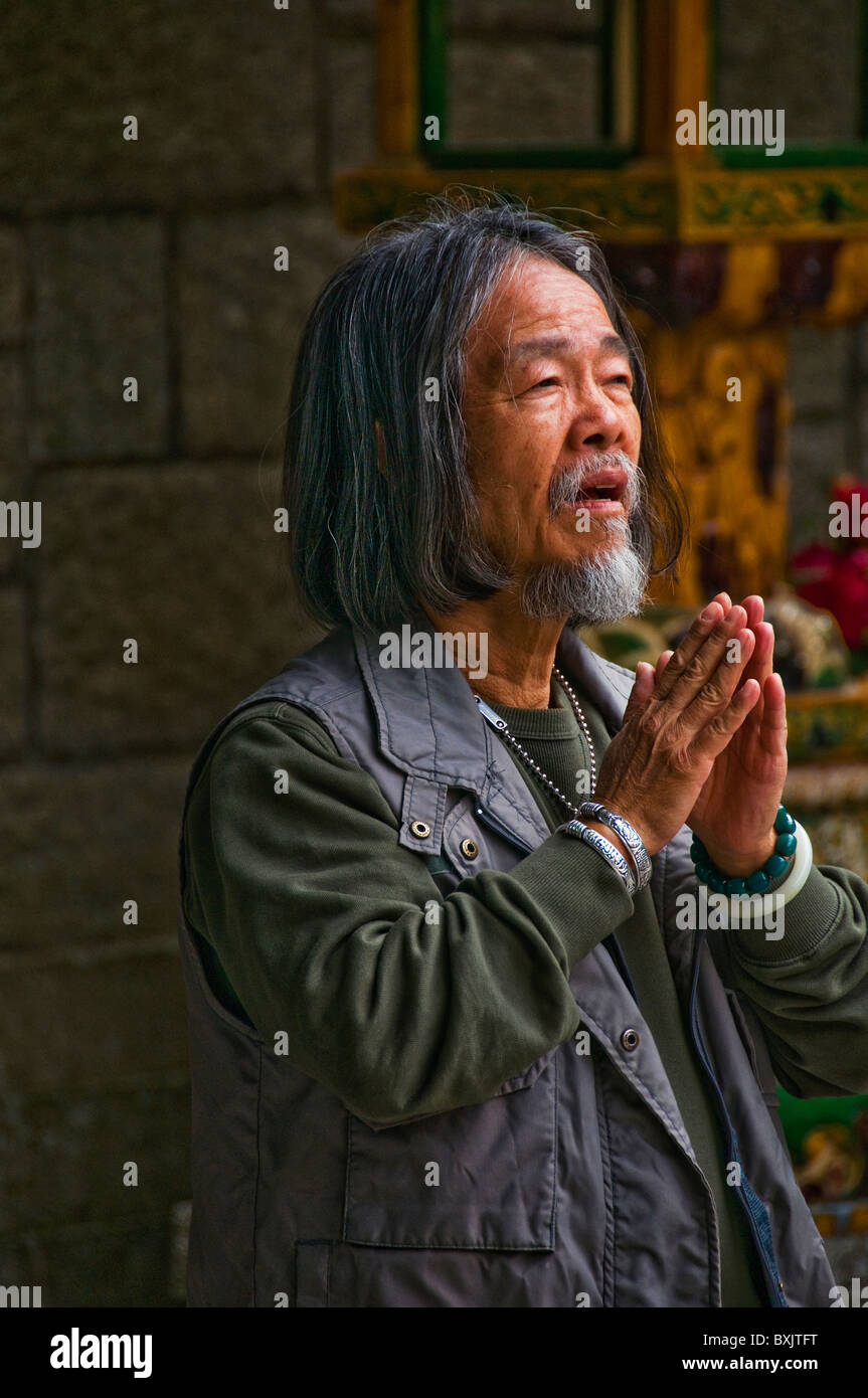 Expressive Asian man praying Po Lin monastery at Ngong Ping Lantau ...