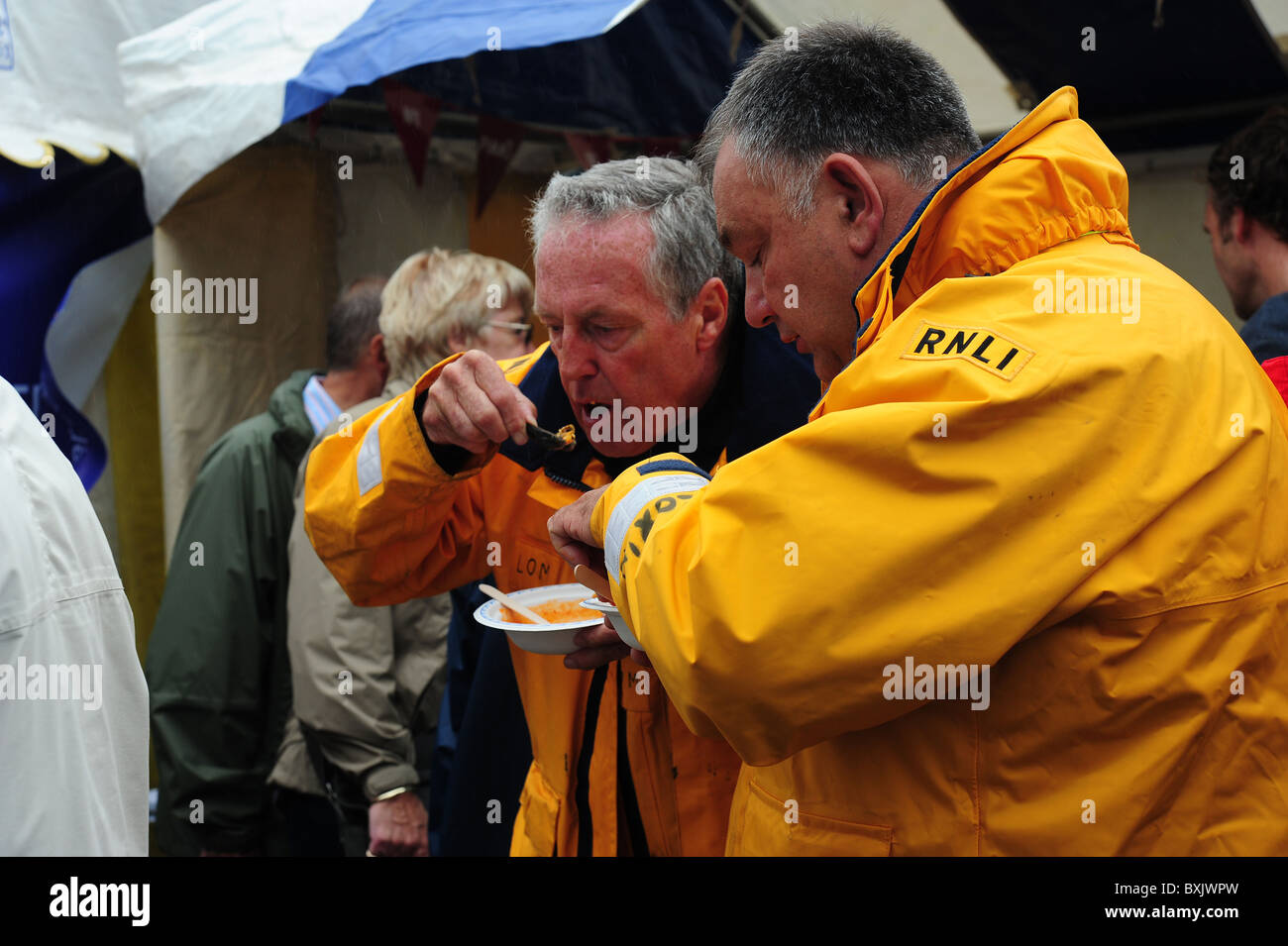 two men from the RNLI enjoy some fish soup during the seafood festival ...