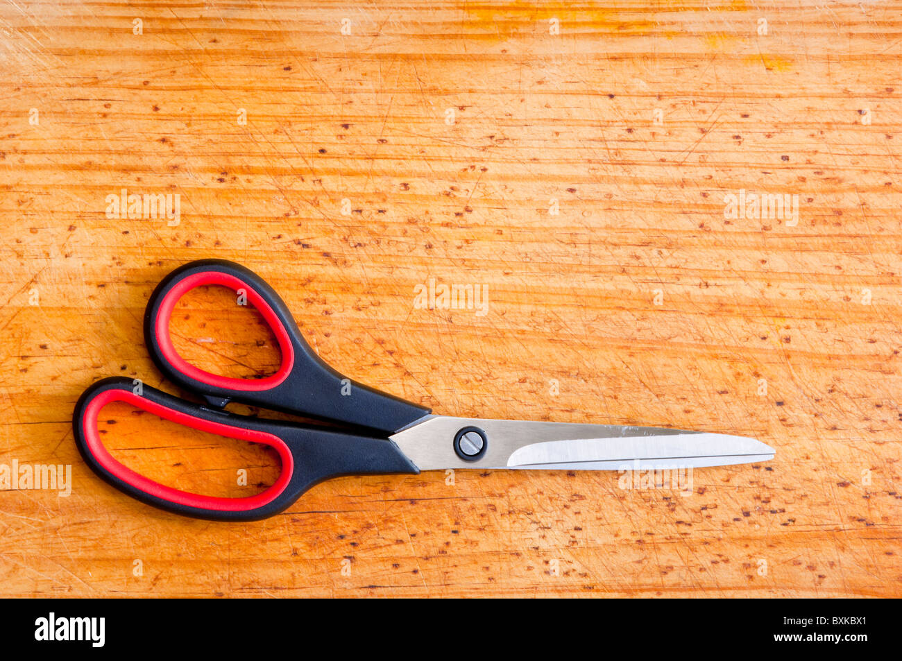Modern scissors sit atop a wooden board Stock Photo - Alamy