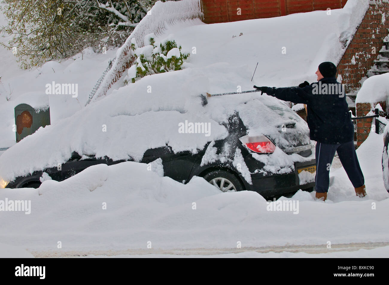 Woman clears thick snow off her car Stock Photo - Alamy
