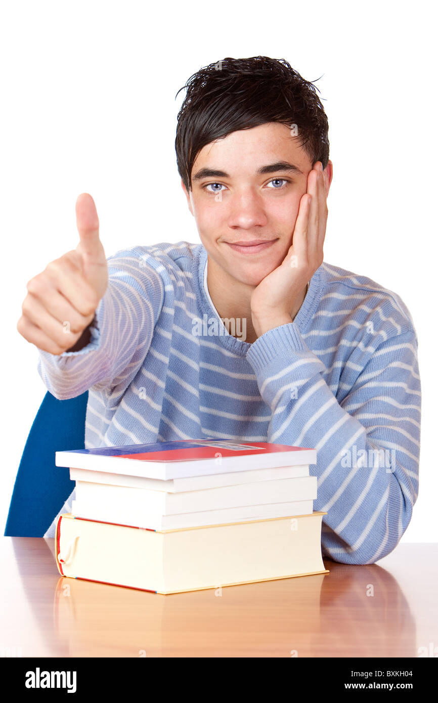 Young happy student sitting on desk with books and shows thumb up ...