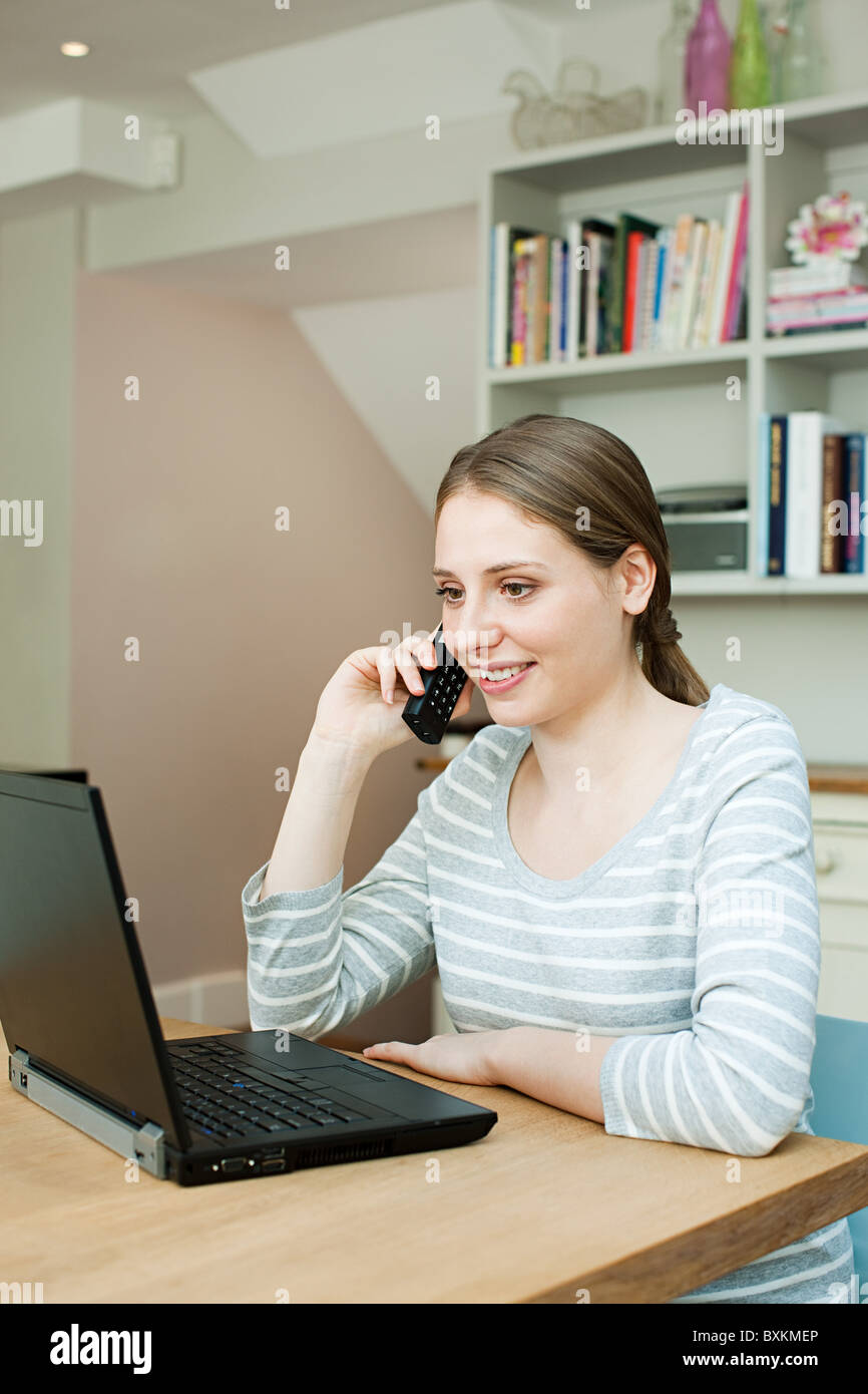 Young woman on table and using phone hi-res stock photography and ...