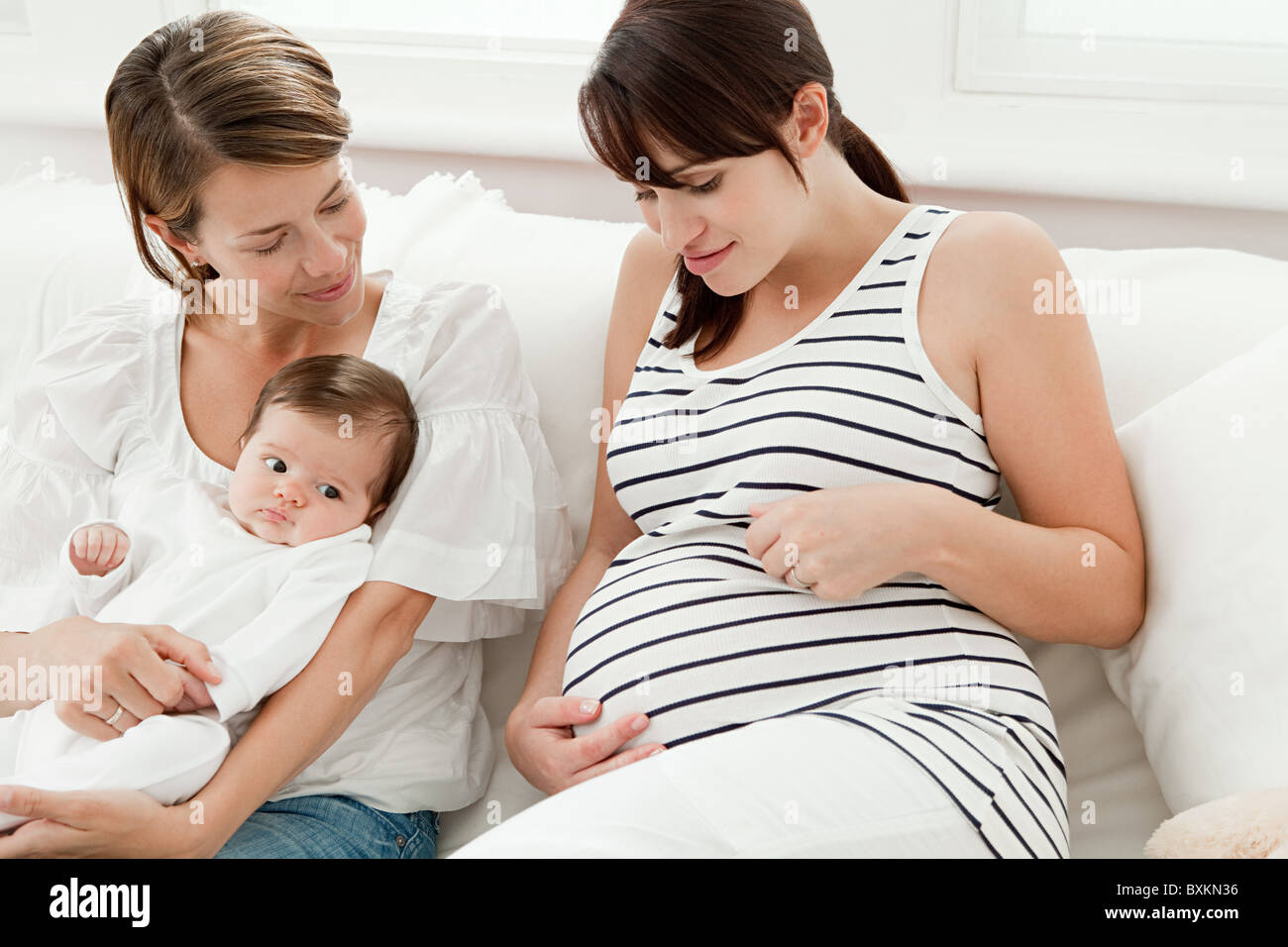 Mother with baby girl and pregnant friend Stock Photo - Alamy