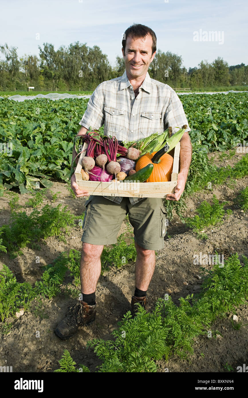 Man holding wooden create of freshly farmed vegetables Stock Photo - Alamy