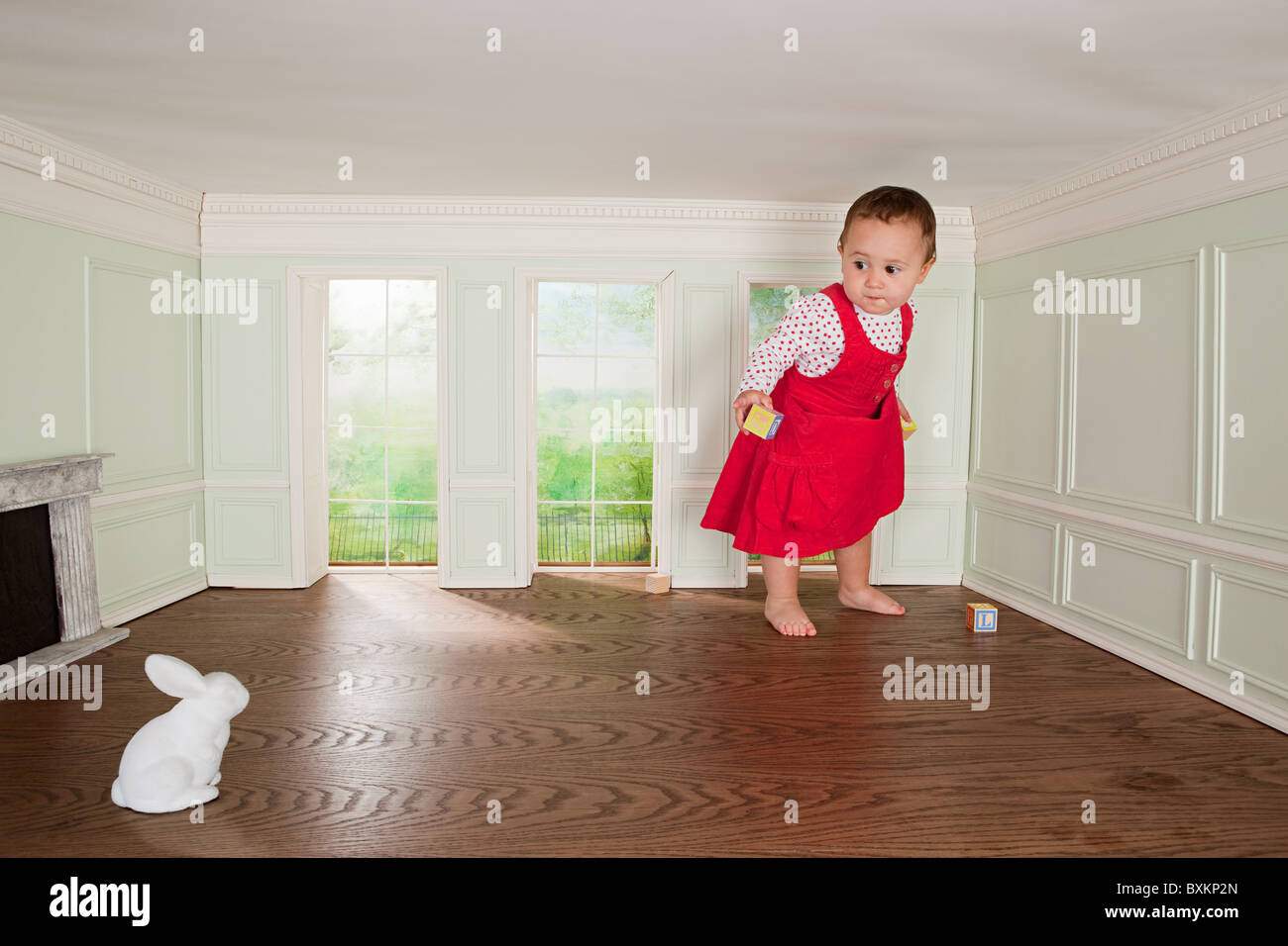 Toddler girl in a tiny room, looking at rabbit Stock Photo - Alamy