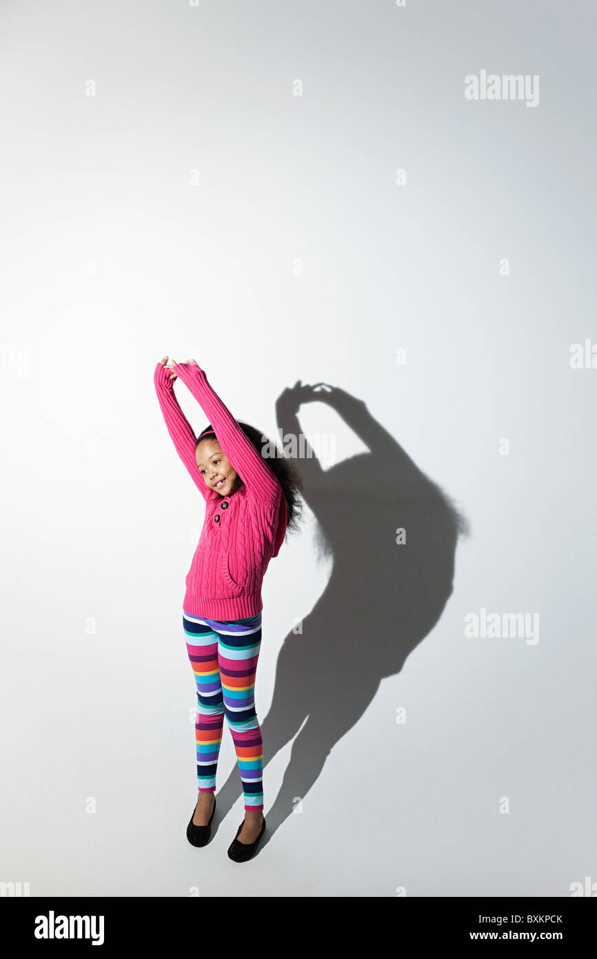 Girl with arms raised and shadow Stock Photo - Alamy