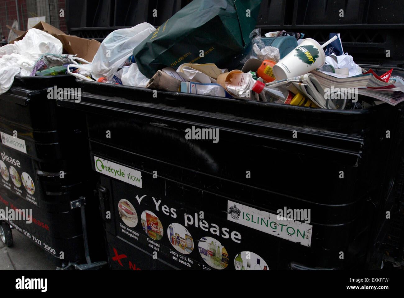 Recycling bin filled with ordinary refuse Stock Photo - Alamy