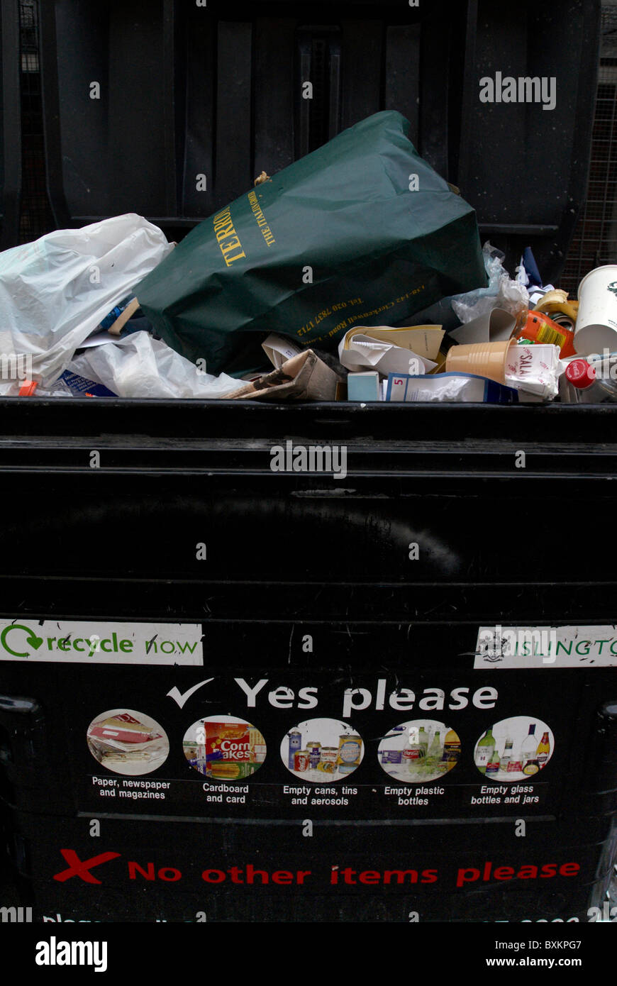Recycling bin filled with ordinary refuse Stock Photo - Alamy