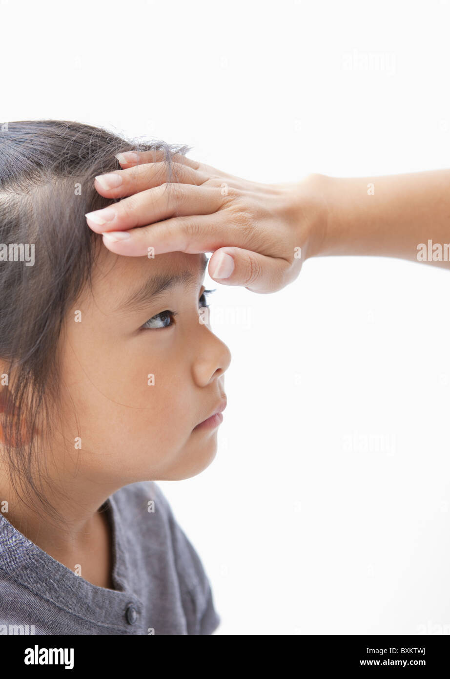 Mother's hand placing on her daughter's forehead Stock Photo - Alamy