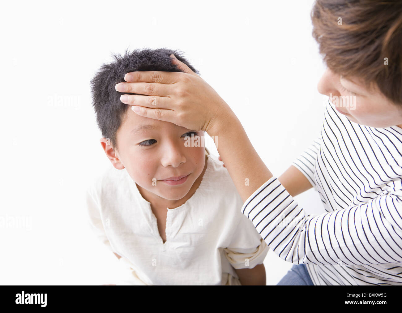 Mother placing her hand on her son's forehead Stock Photo - Alamy