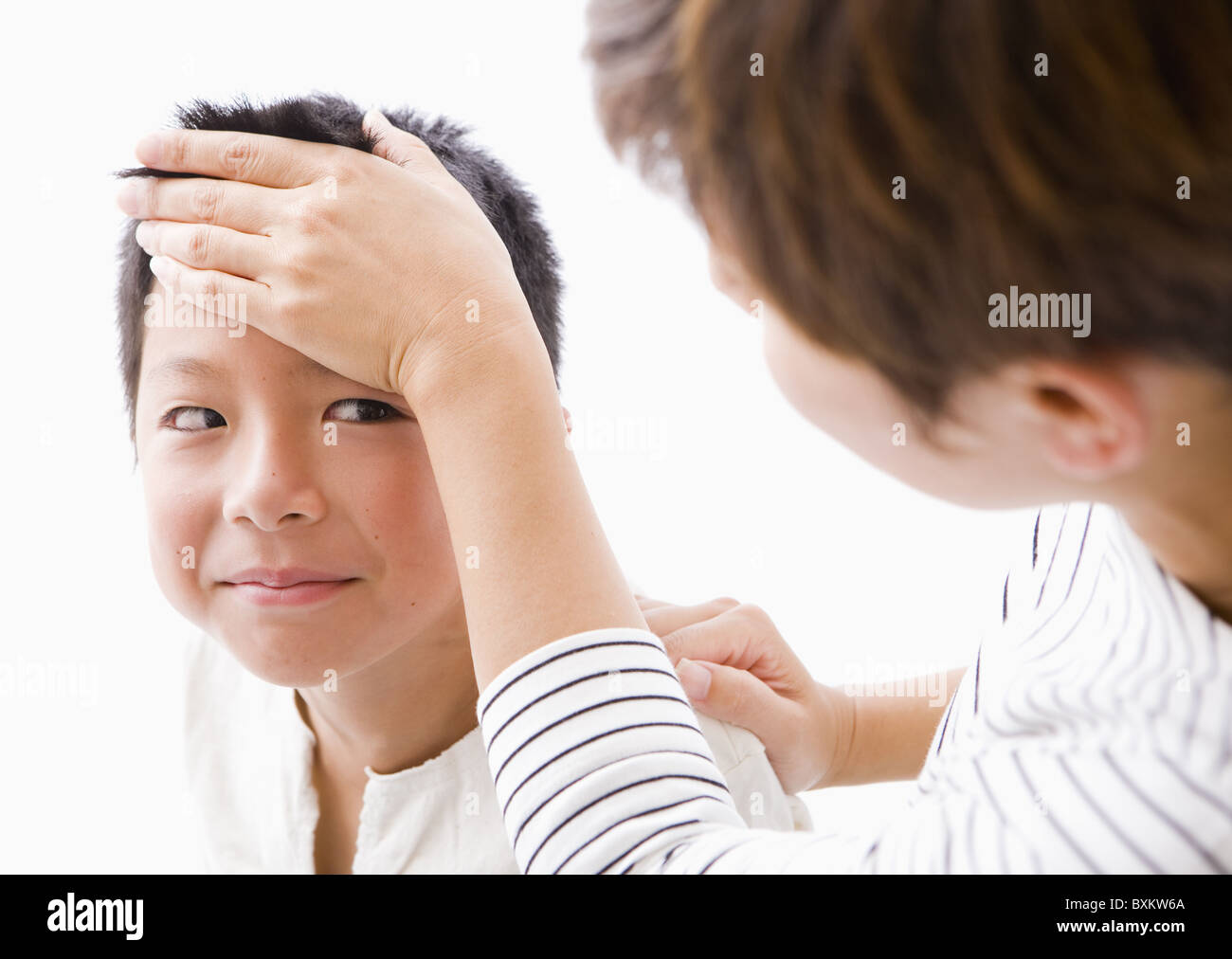 Mother placing her hand on her son's forehead Stock Photo - Alamy