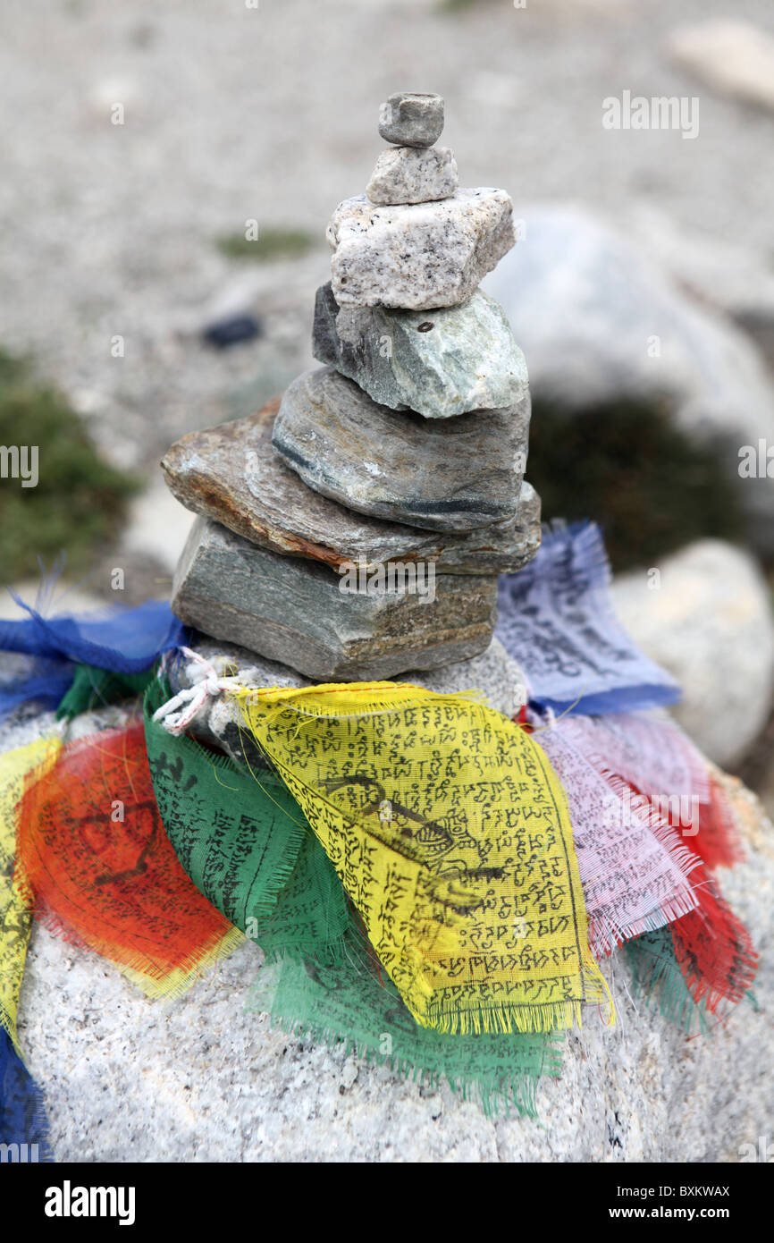 A small piles of rocks built upon prayer flags at everest base camp or ...