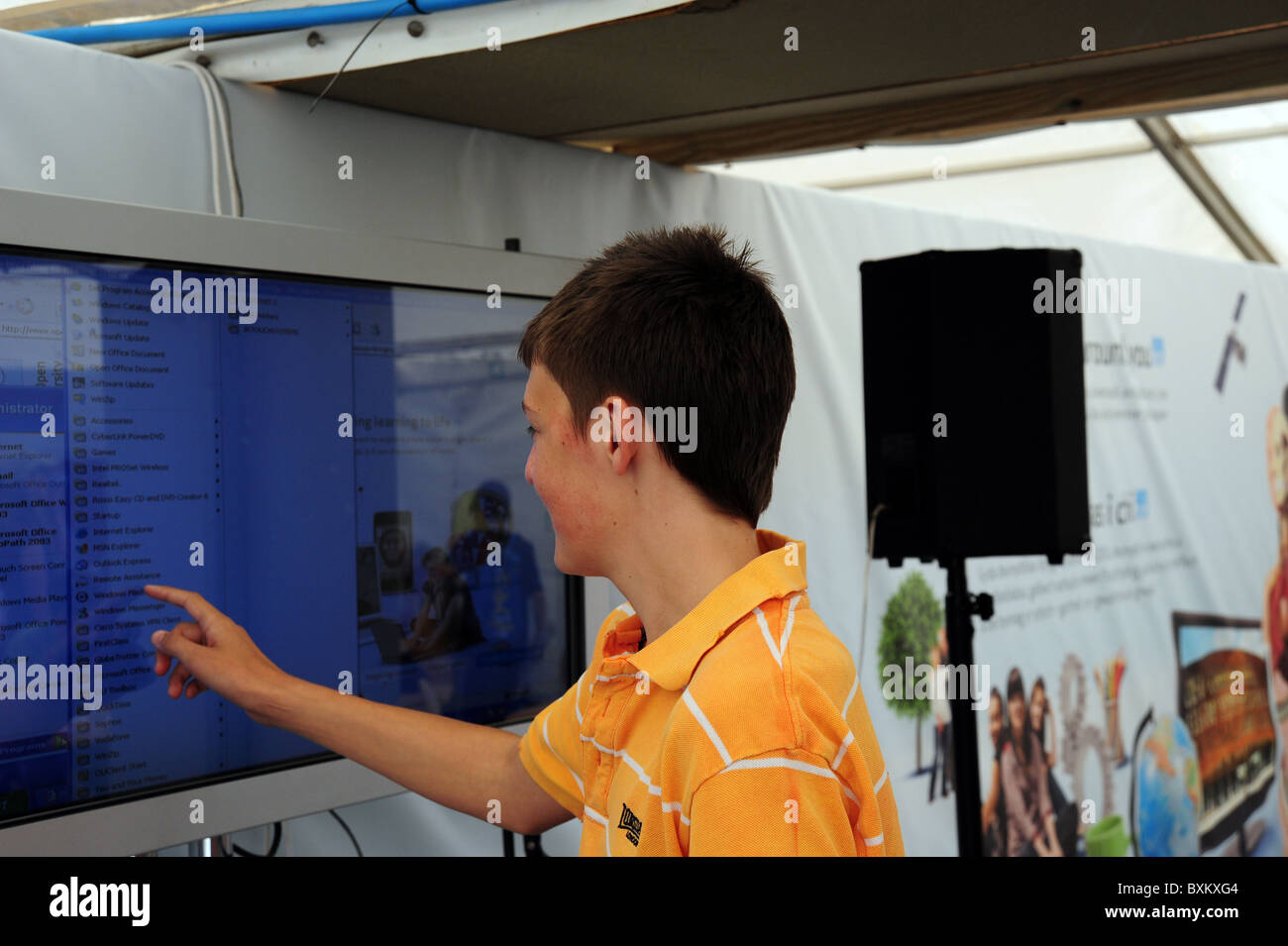 a young boy using a touch screen TV during a display on education Stock ...