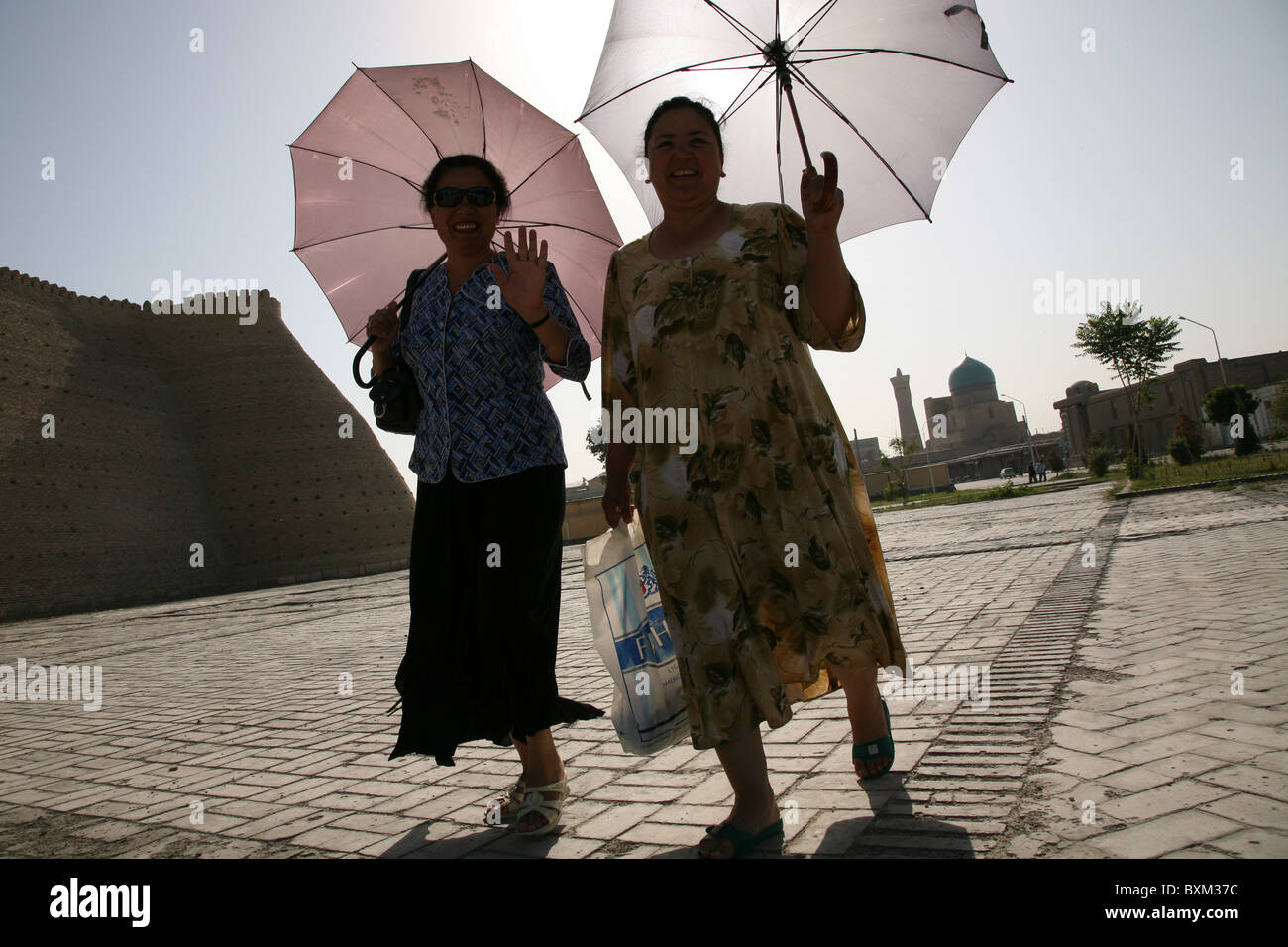 Two Uzbek women walking in the historical centre of Bukhara, Uzbekistan ...