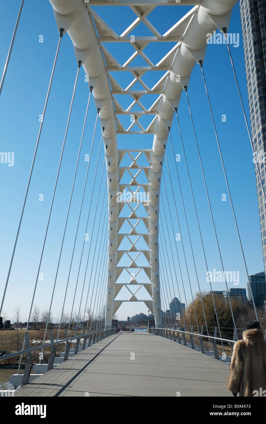 Lady in fur coat walking across a suspension bridge. Humber River ...