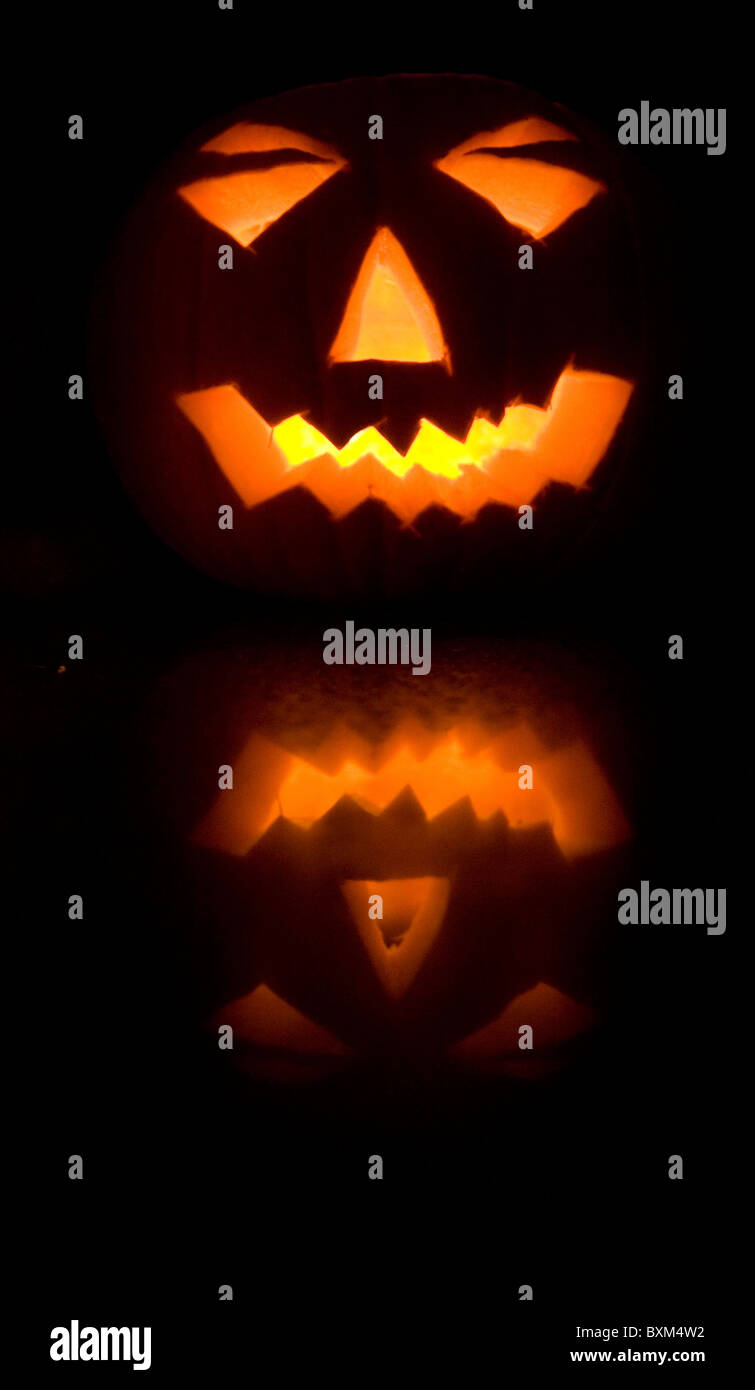 scary halloween pumpkin glowing face with reflection Stock Photo - Alamy