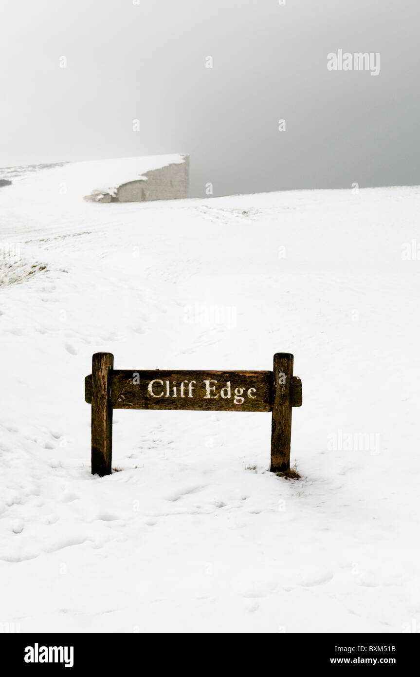 Cliff Edge sign at Beachy Head, East Sussex, UK in the snow with poor ...