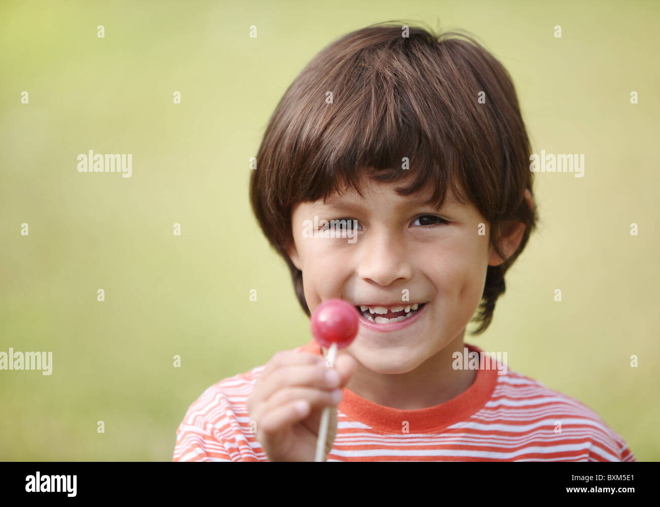 Happy hispanic boy with lollypop in natural light Stock Photo - Alamy