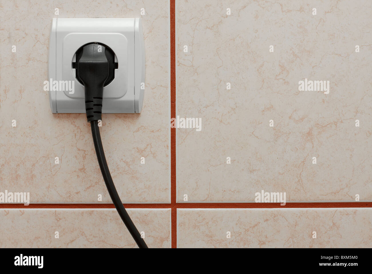 Electric outlet on a wall with tiles Stock Photo - Alamy