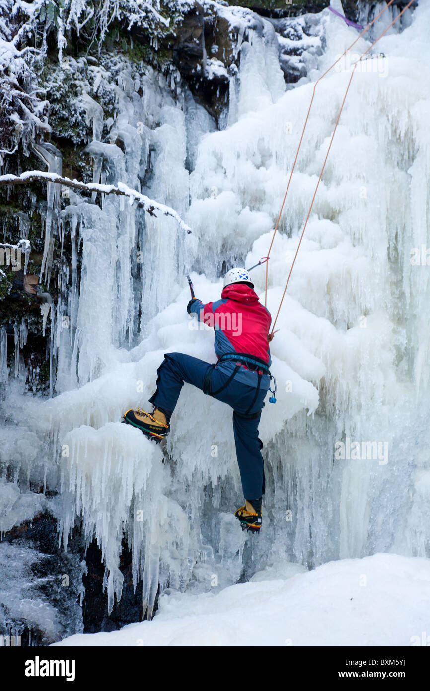 Climber doing an ice climb on a frozen waterfall (Lynn Falls) in North ...