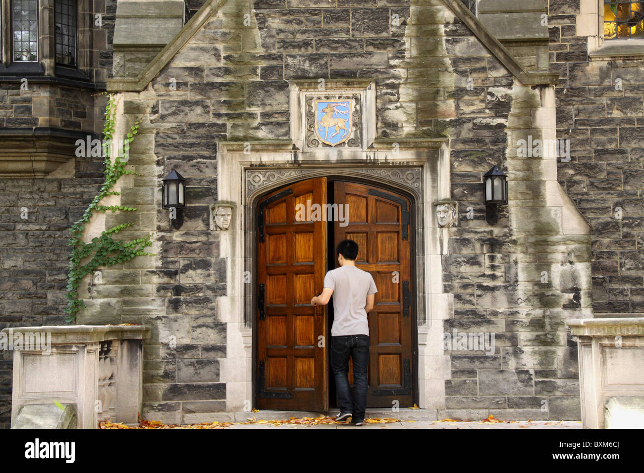 Student entering gothic style college building Stock Photo - Alamy