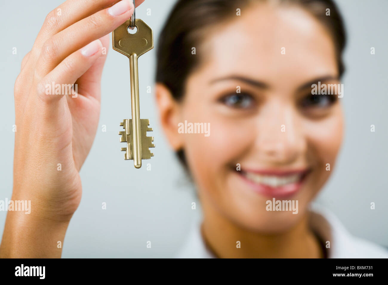 Smiling business woman is holding the key Stock Photo - Alamy