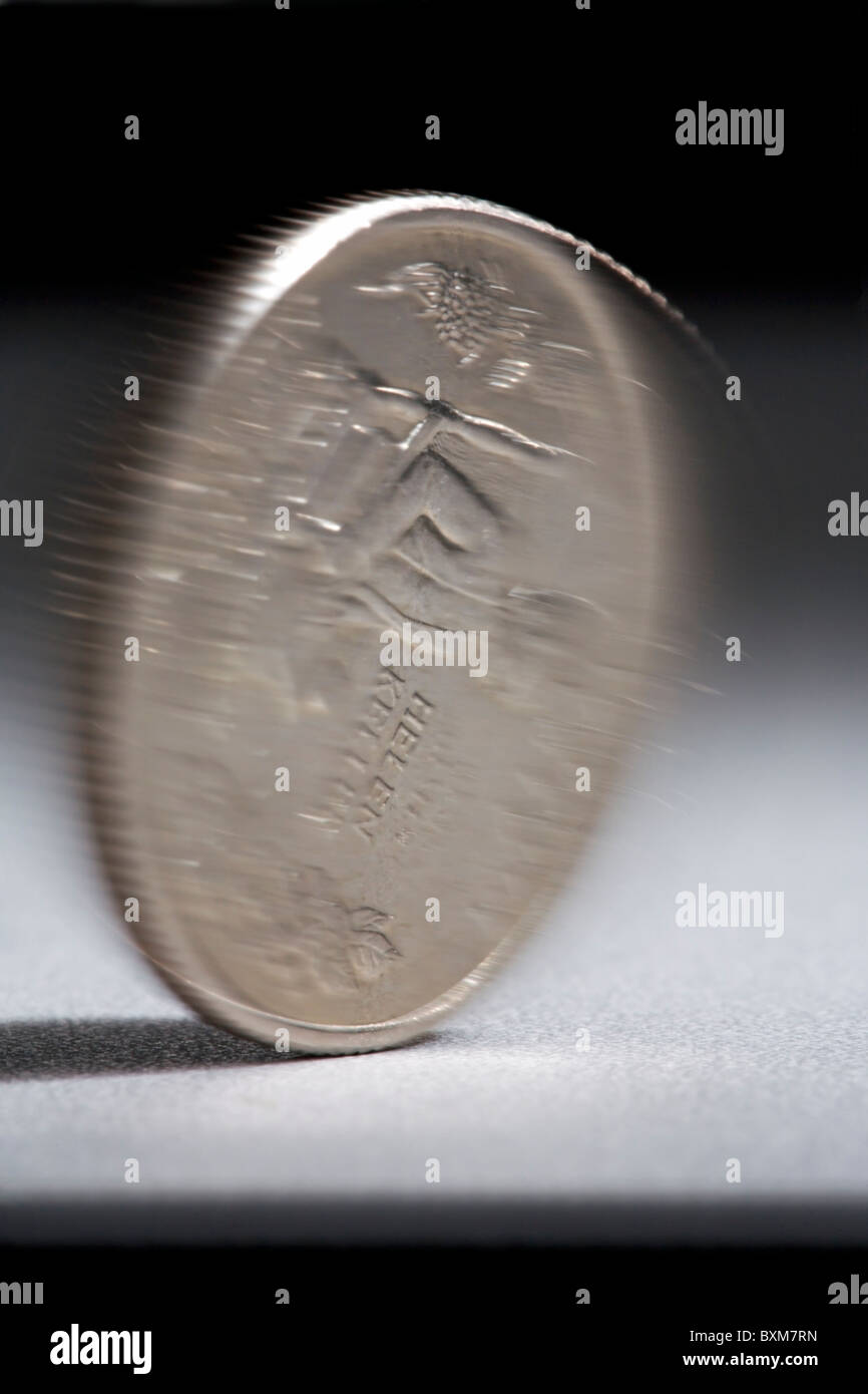 Isolated metal coin spinning around on the table Stock Photo - Alamy