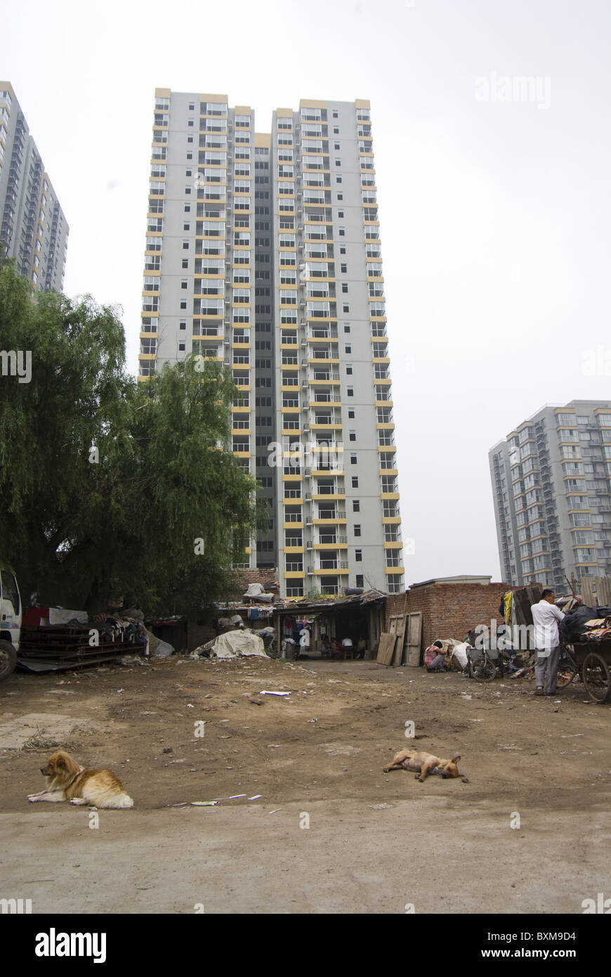 courtyard with decrepit buildings in front of new apartment tower ...
