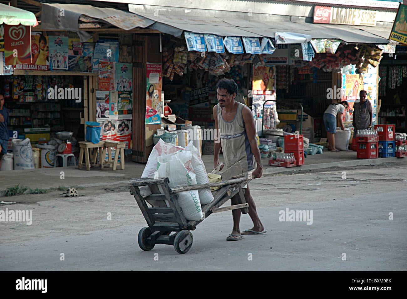 Philippines, worker pushing heavy loaded cart in Dimiao Bohol Stock ...