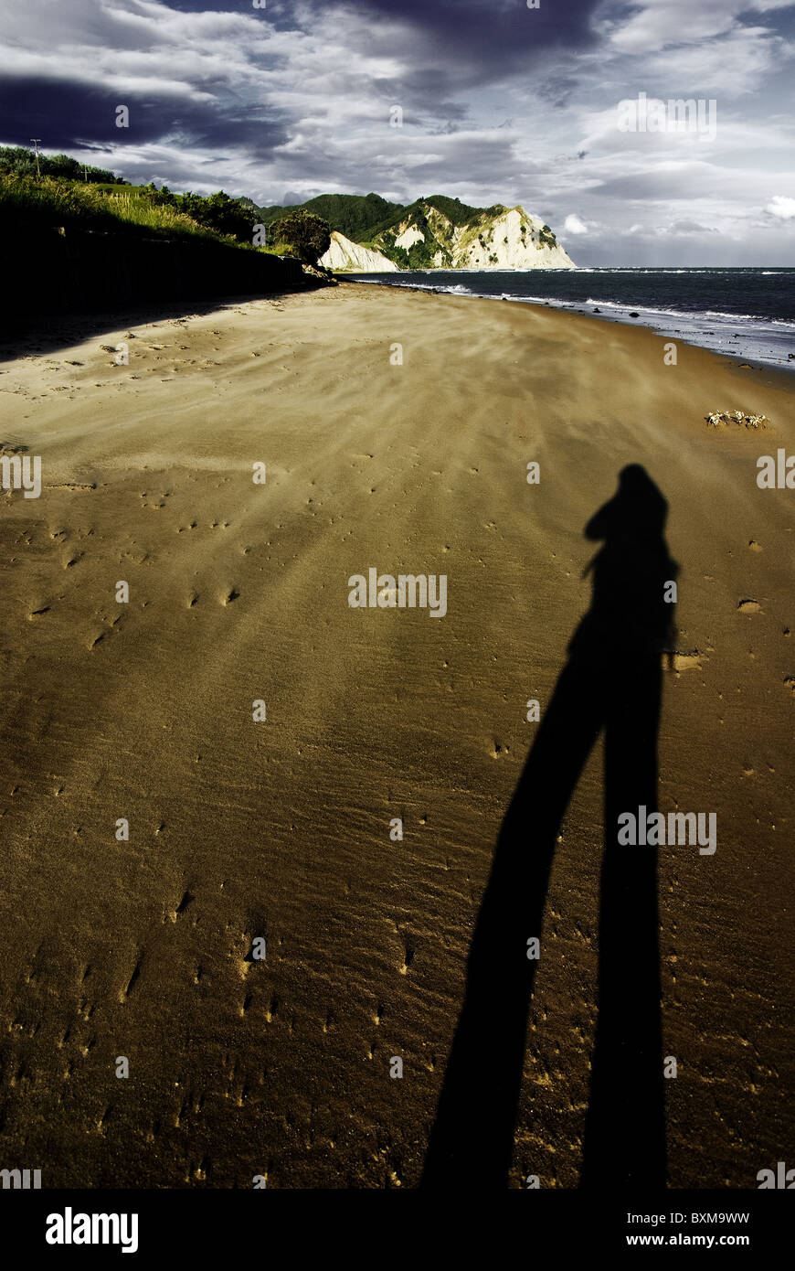 Man's shadow on a stormy beach in tokomaru bay, new zealand Stock Photo ...