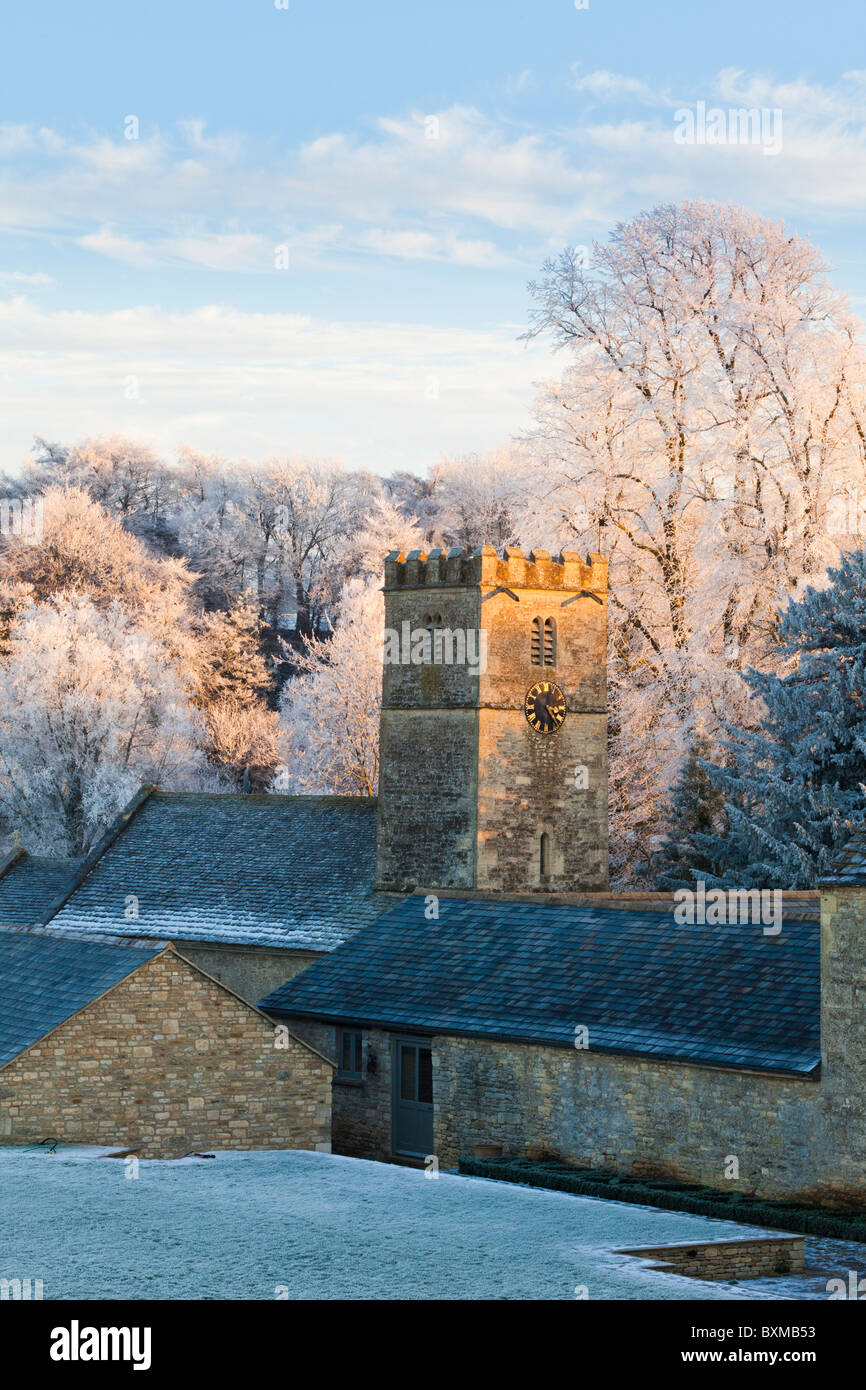 The sun setting on St Andrews church in the hoar frost covered Cotswold ...
