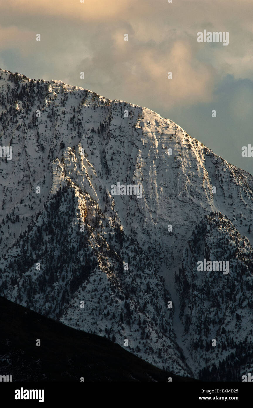Sheer rock face covered with snow and ice in low light at dusk Stock ...