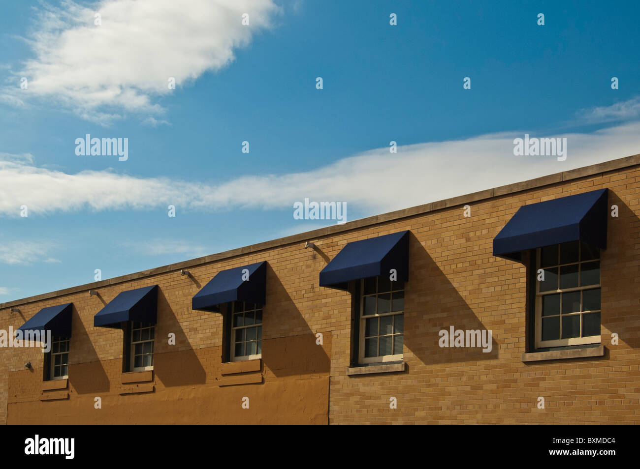 Five windows with blue awnings Stock Photo - Alamy