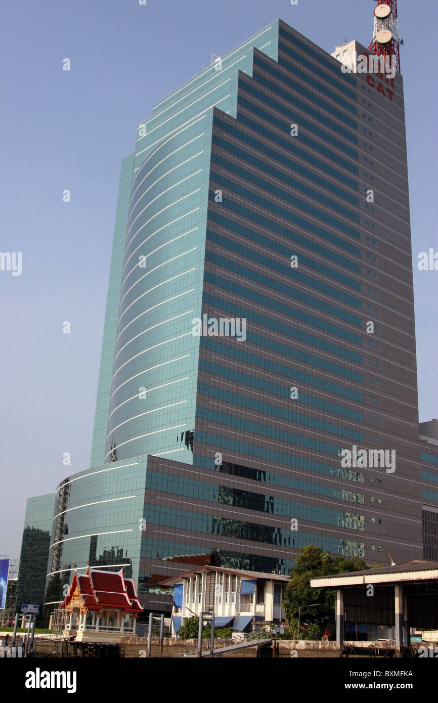 A tall and modern glass office building is reflecting the sky on the ...