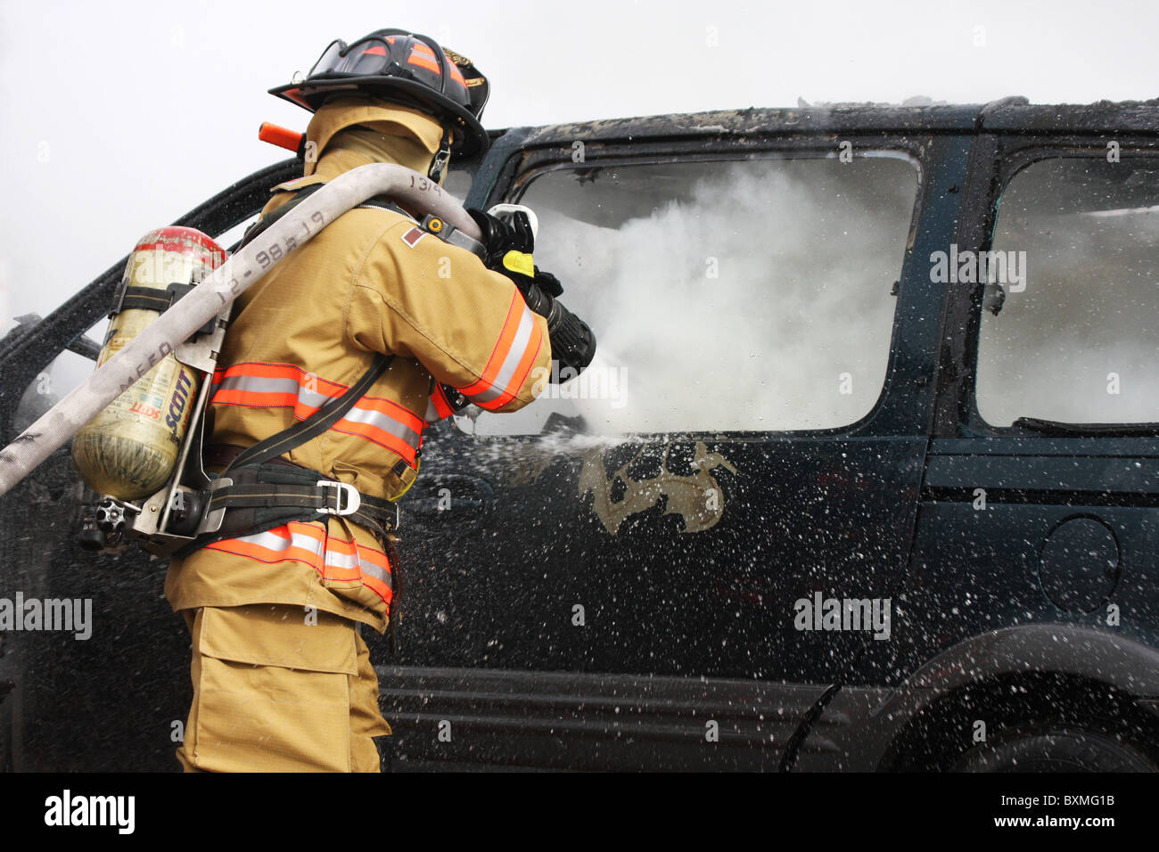 Firefighter on a hoseline fighting a car fire Stock Photo - Alamy