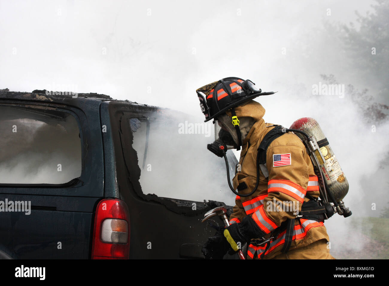Firefighter fighting a car fire Stock Photo - Alamy