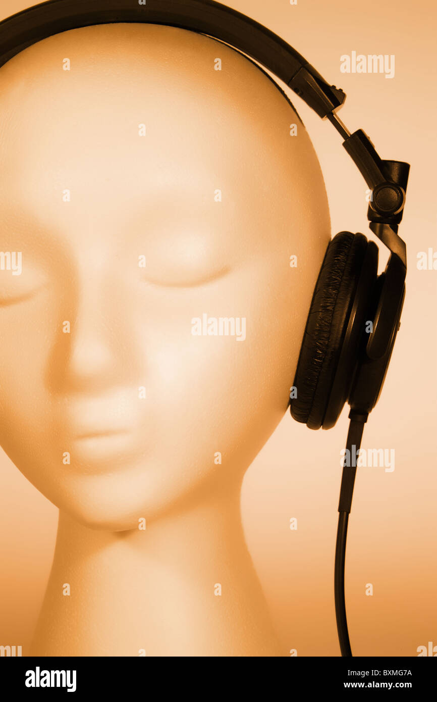 Female mannequin head listening to music with orange overlay Stock ...
