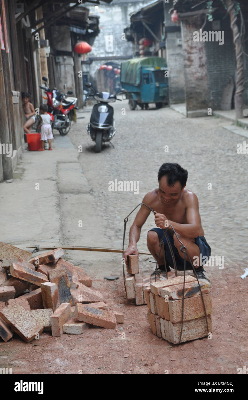 Man working in the streets of Daxu ancient town, Southern China Stock ...