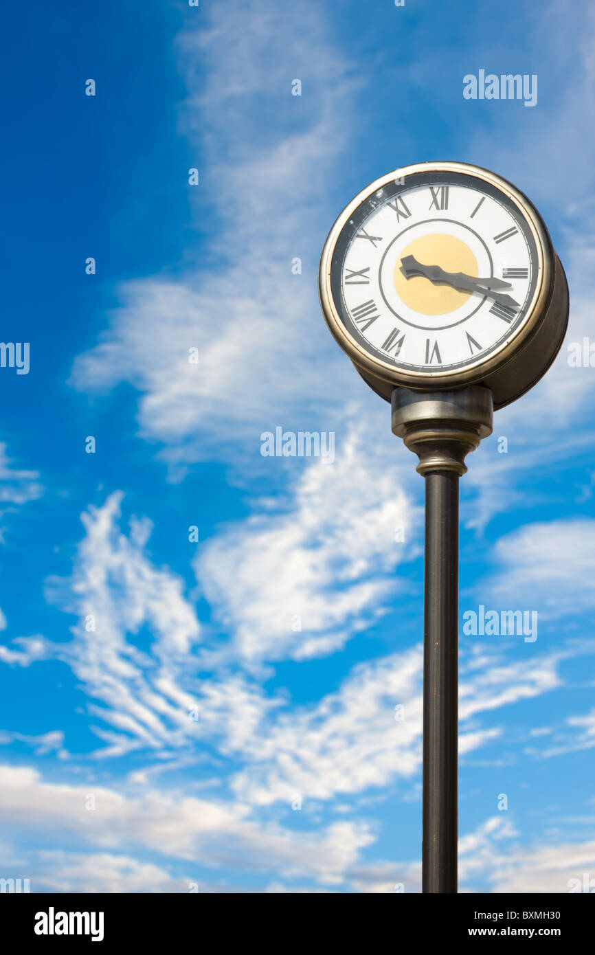 Street clock in the afternoon against a blue sky Stock Photo - Alamy