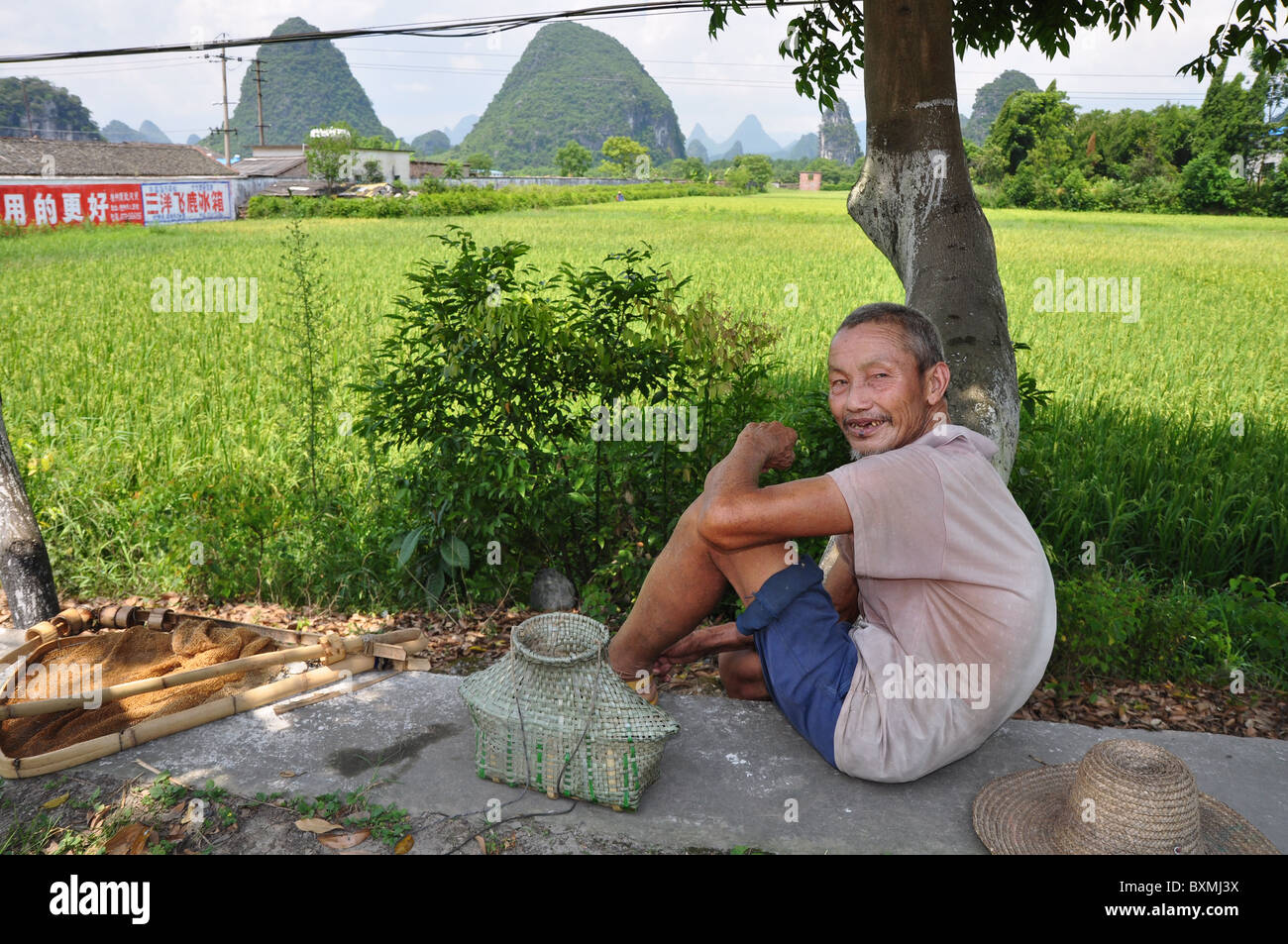 An old, happy man is resting under a tree in Guilin area, Southern ...